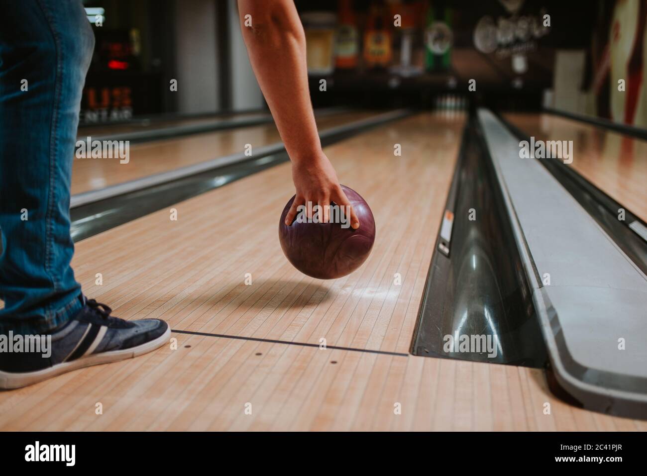 Close up of the hand of a caucasian man throwing a ball in a bowling ...
