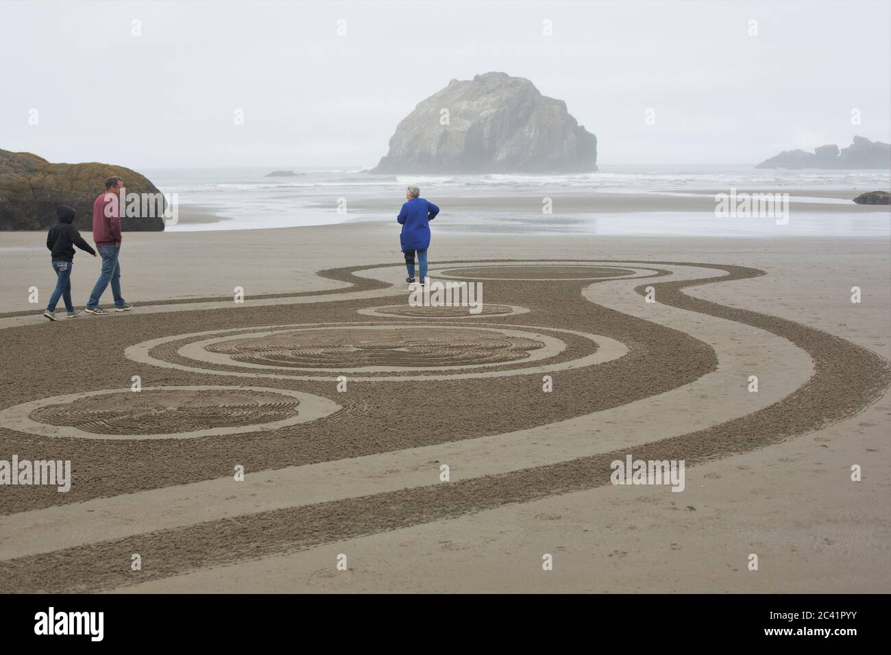 People walking a Circles in the Sand labyrinth at Face Rock Beach in ...