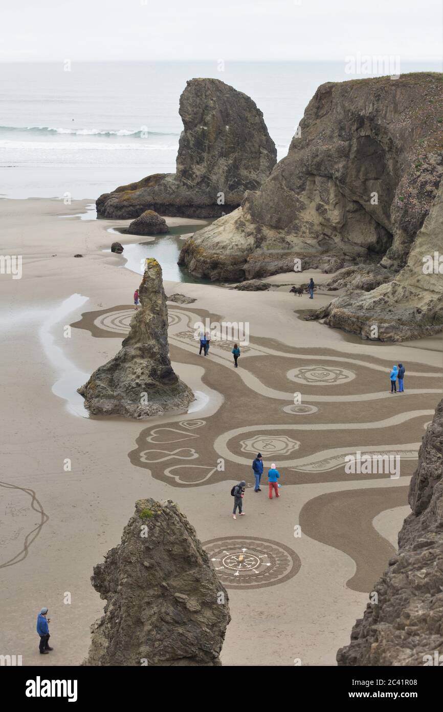 People walking a Circles in the Sand labyrinth at Face Rock Beach in ...