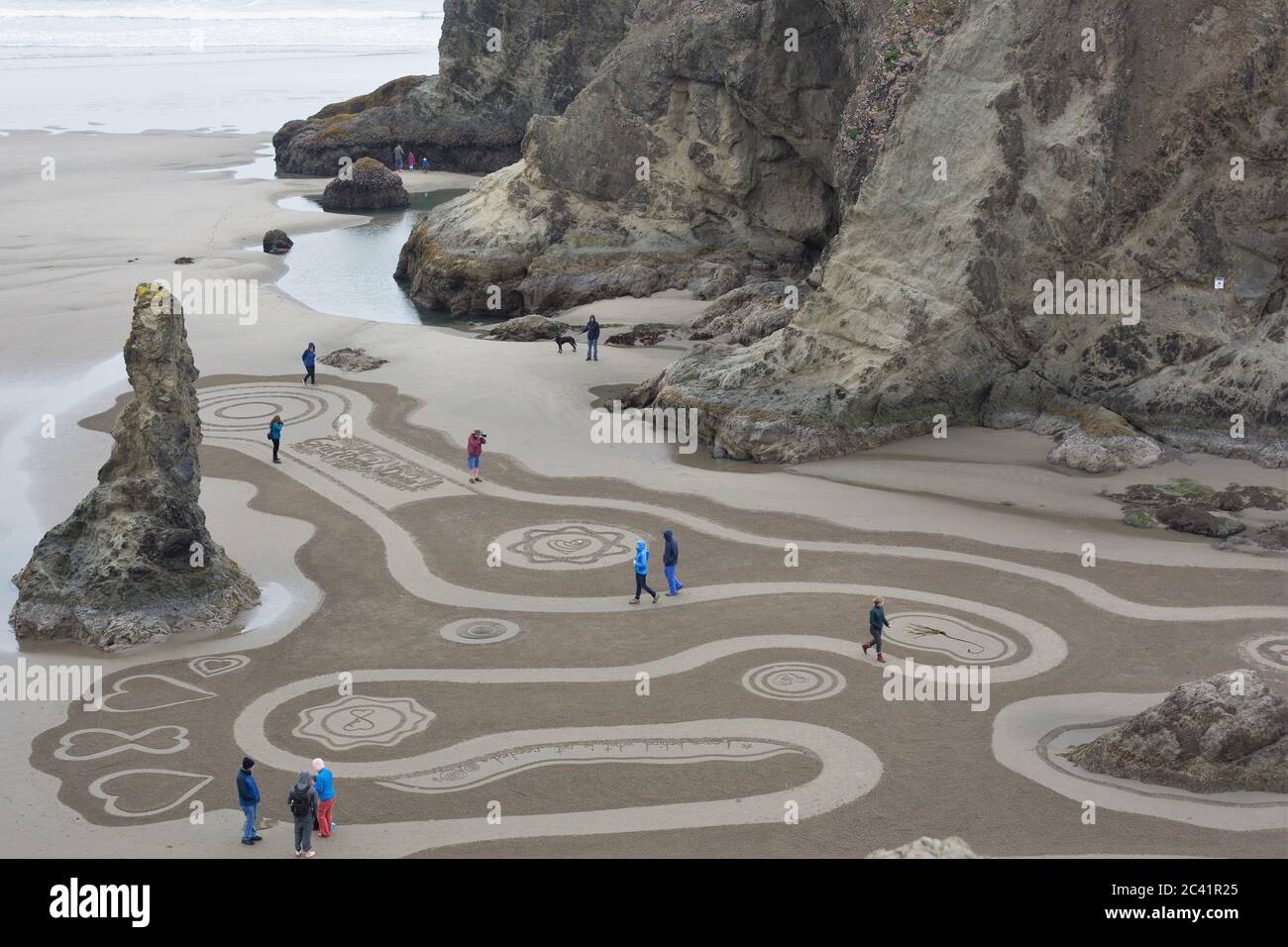 People walking a Circles in the Sand labyrinth at Face Rock Beach in ...