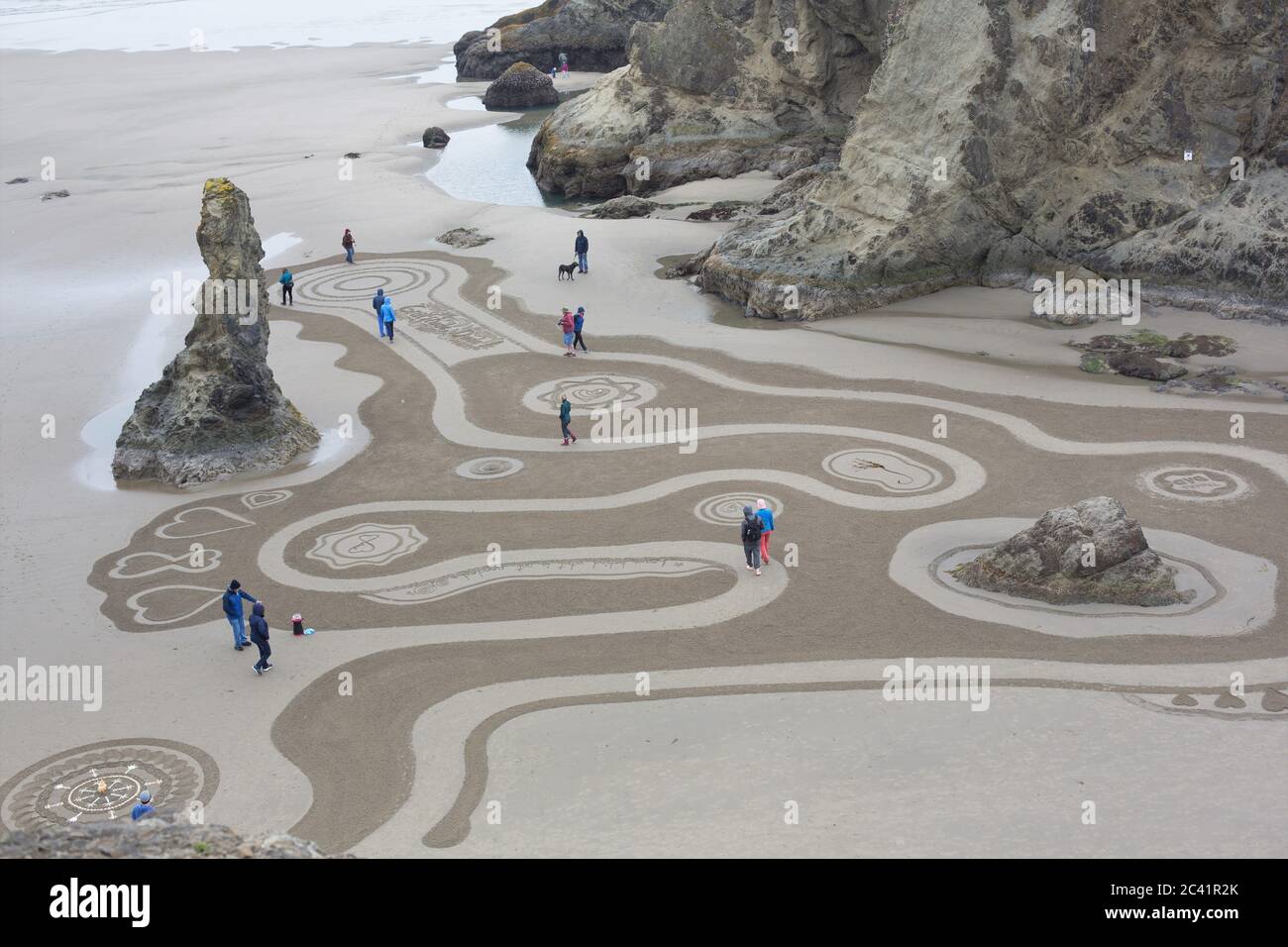 People walking a Circles in the Sand labyrinth at Face Rock Beach in ...