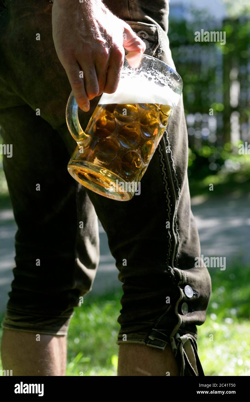 Man in leather pants holds a beer mug in his hand - alcohol - tradition ...