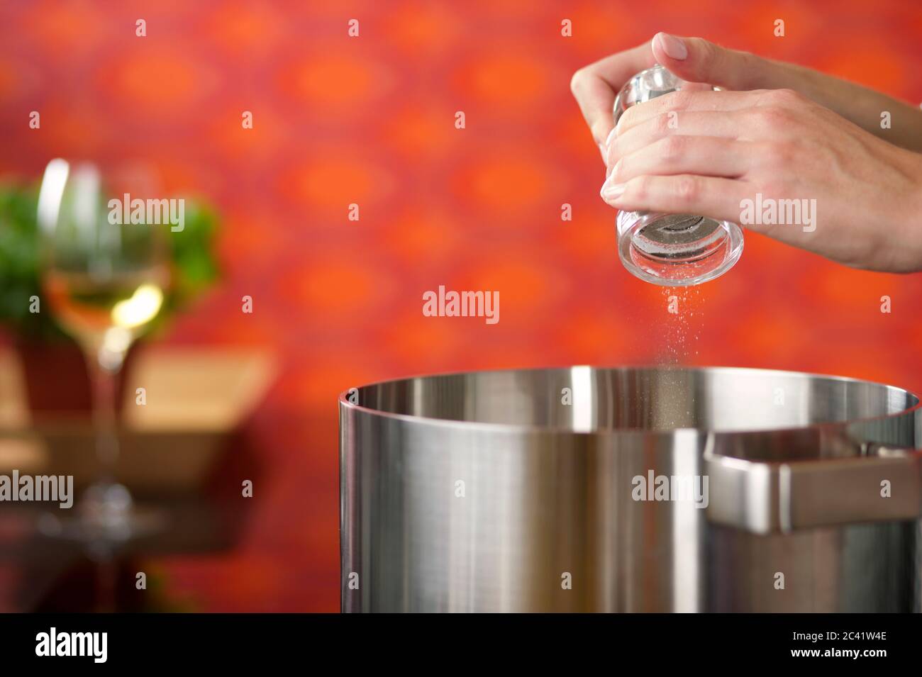 Woman puts salt in a saucepan Stock Photo - Alamy