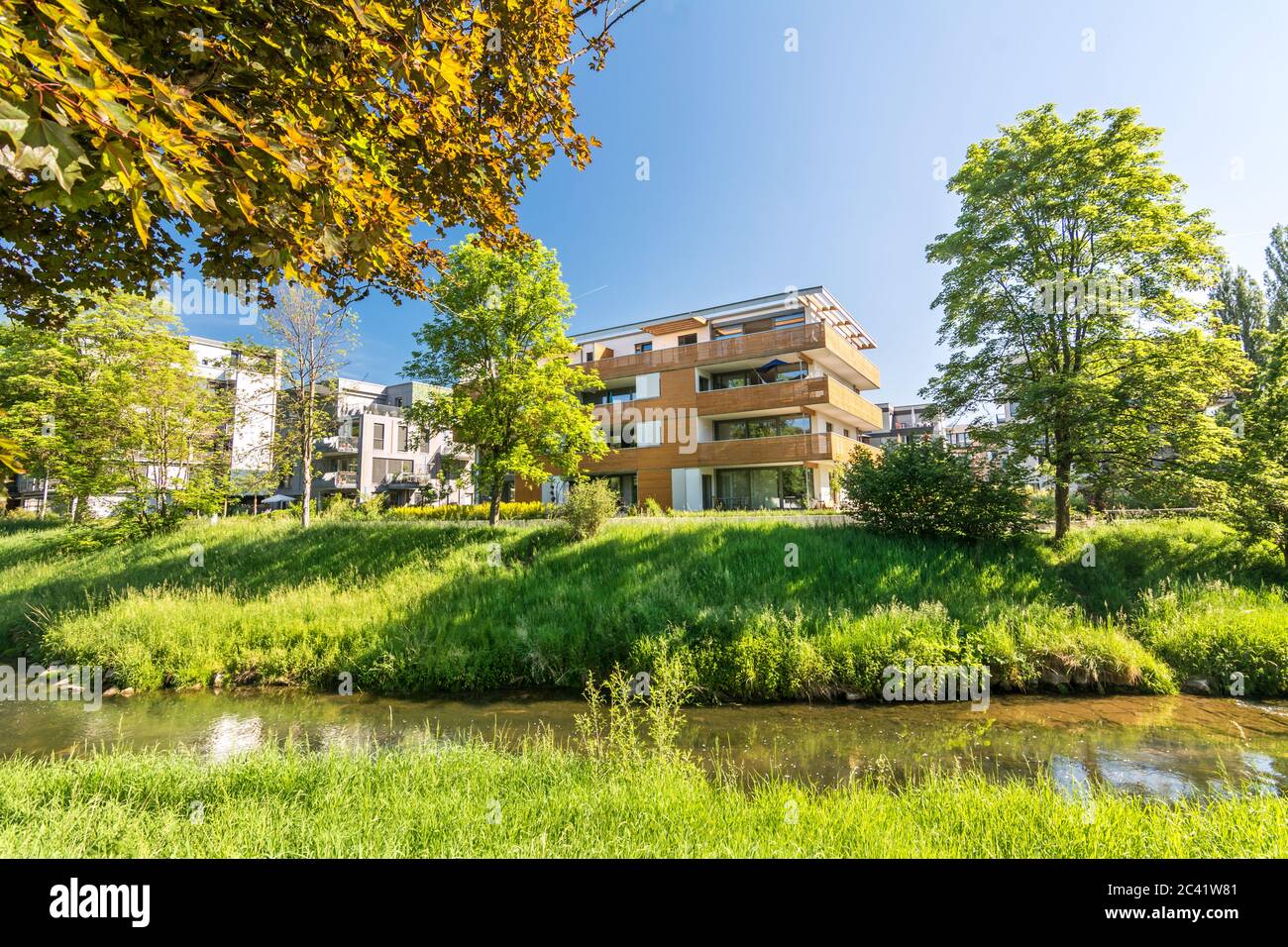 Modern buildings in nice green neighbourhood near a stream Stock Photo ...