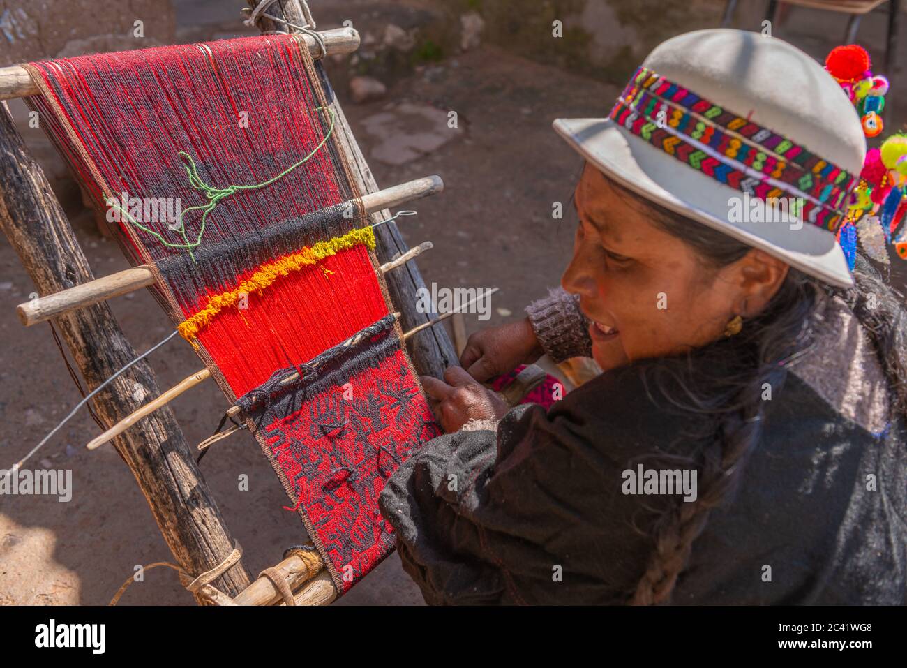 Elderly woman weaver weaving local red and black Jalq´a art pattern ...