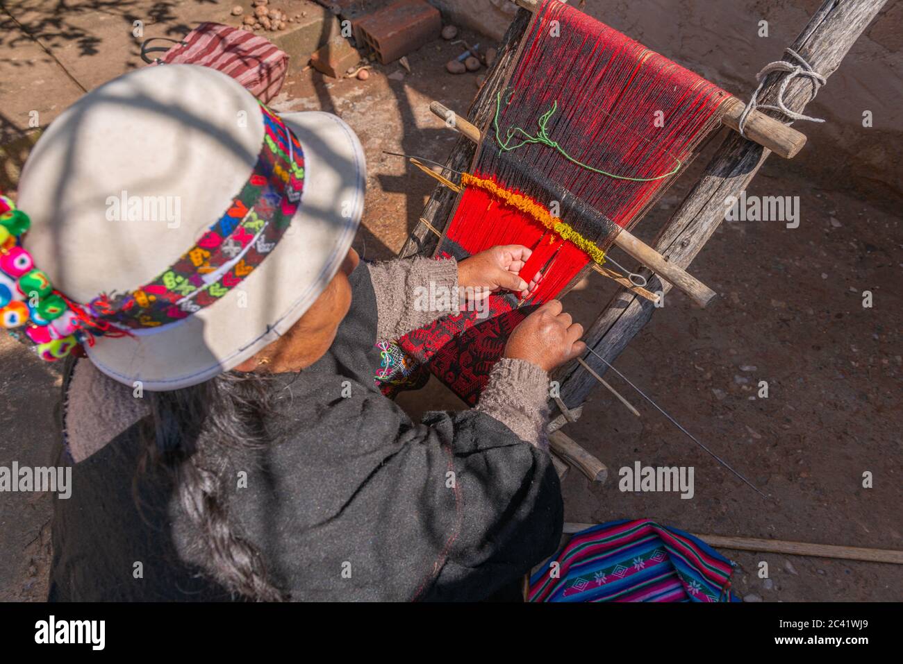 Elderly woman weaver weaving local red and black Jalq´a art pattern ...