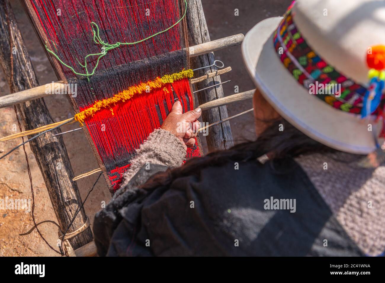 Elderly woman weaver weaving local red and black Jalq´a art pattern ...