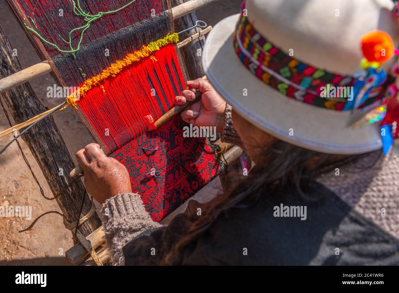 Elderly woman weaver weaving local red and black Jalq´a art pattern ...
