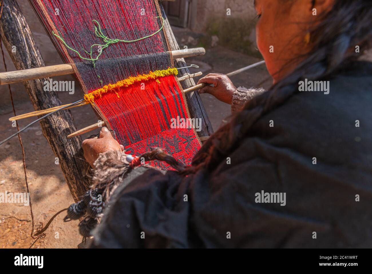Elderly woman weaver weaving local red and black Jalq´a art pattern ...