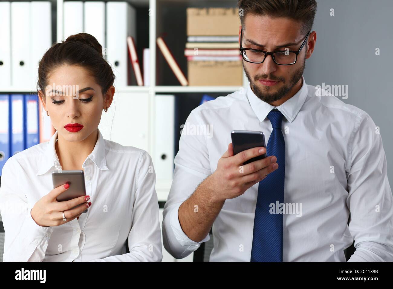 Two corporate colleagues using smartphone hi-res stock photography and ...