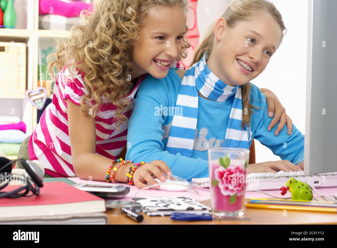 Two laughing girls use a computer Stock Photo - Alamy