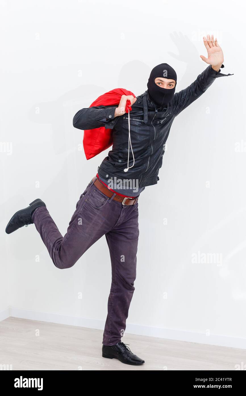 Full length of robber holding bag at home Stock Photo - Alamy
