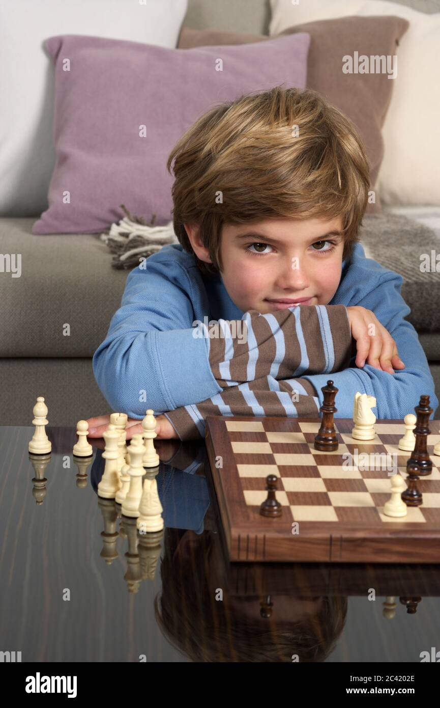 Boy plays chess, smiles at camera Stock Photo - Alamy