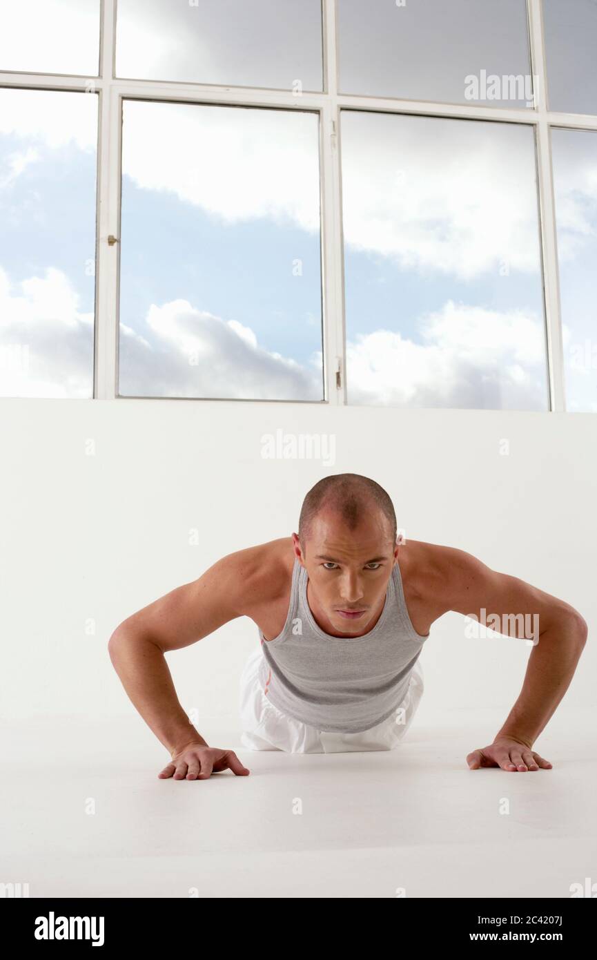 Young man doing pushups - physical exercises - studio Stock Photo - Alamy
