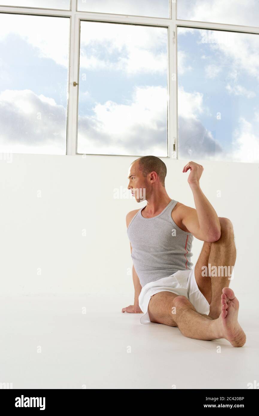 Young man stretches - physical exercises - studio Stock Photo - Alamy
