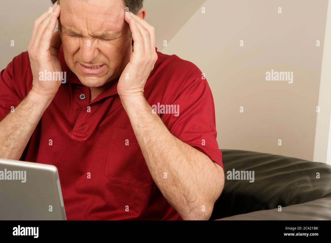 Elderly man with laptop has a headache Stock Photo - Alamy