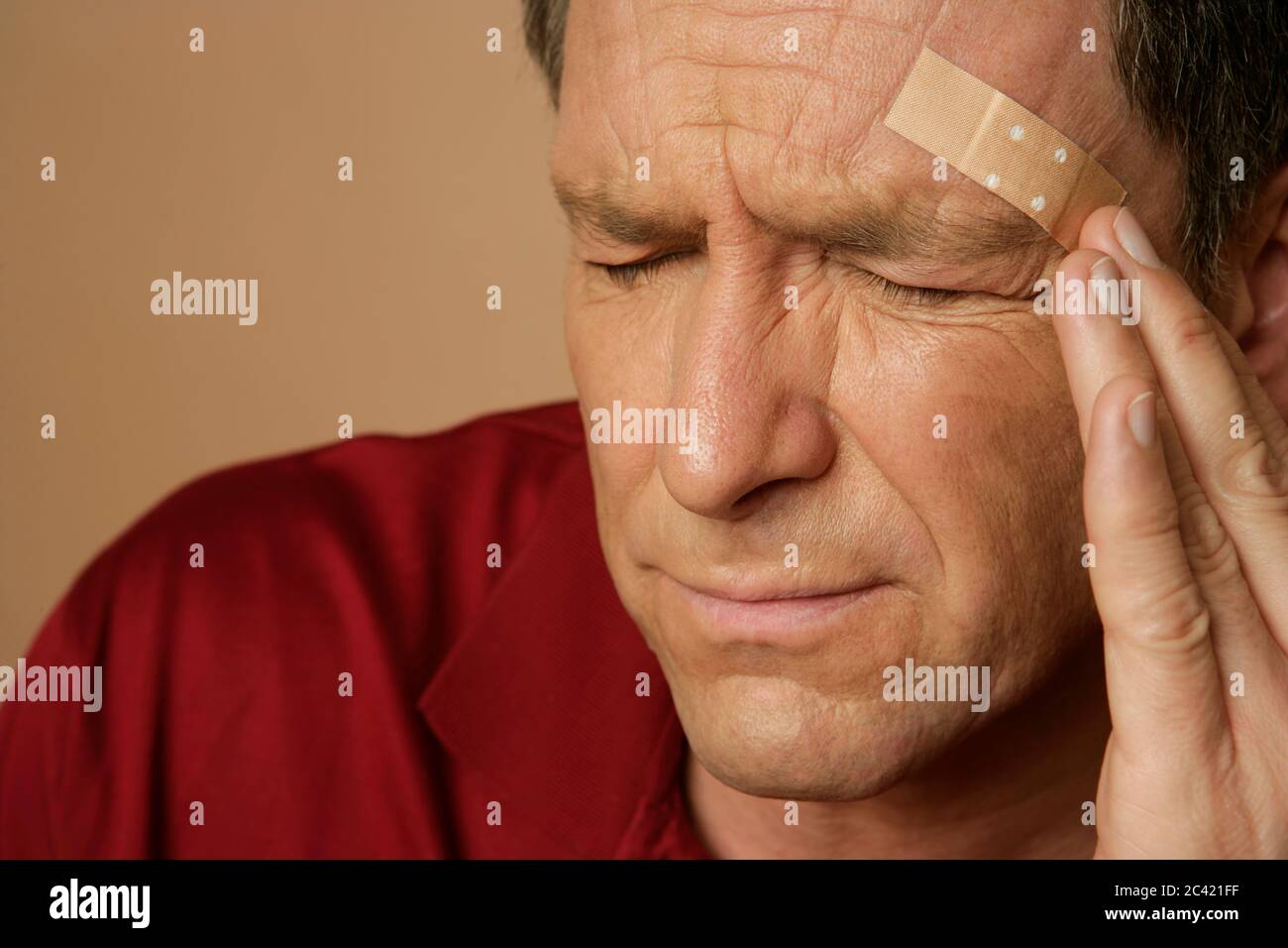 Elderly man with plaster on his forehead has a headache Stock Photo - Alamy