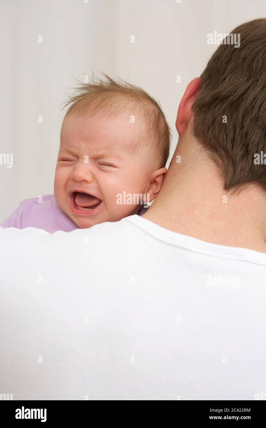 Crying baby in a man's arm Stock Photo - Alamy