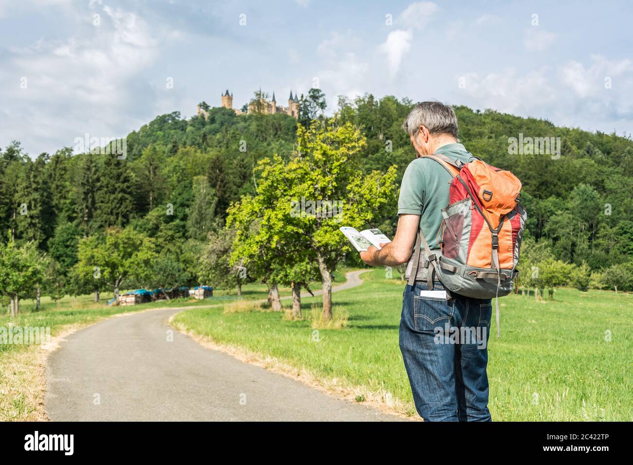 Male hiker looking at his hiking guidebook Stock Photo - Alamy