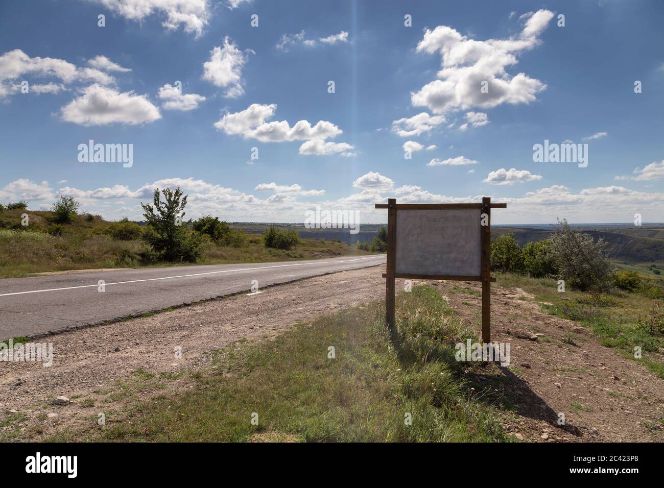 Landscape with signboard. Signboard is near road and there is cloudy ...