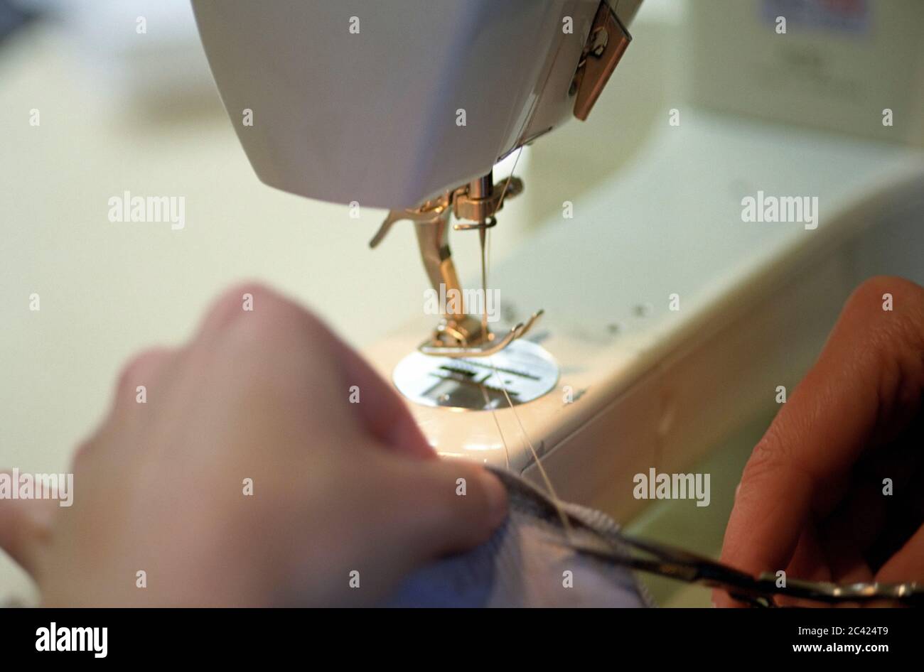 Hand on a sewing machine with blue fabric - hobby - tailoring ...