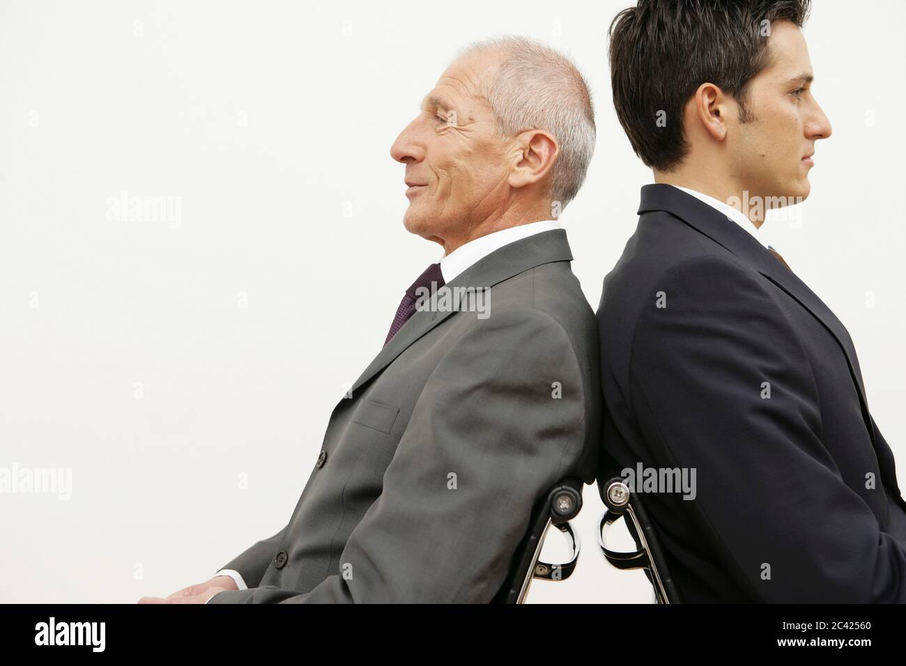 Two men in suits were sitting back to back - interior - job Stock Photo ...