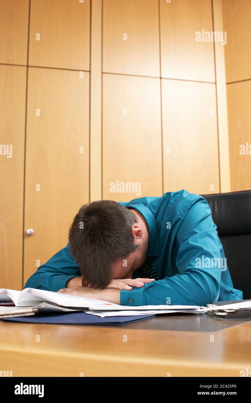 Man resigned leaning over his desk - failure - problems Stock Photo - Alamy