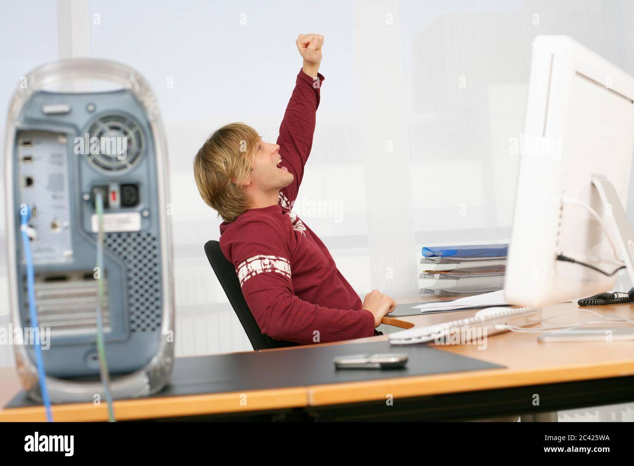 Young man cheers in the office Stock Photo - Alamy