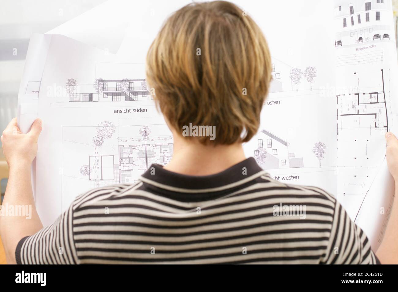 Architect looks at blueprint Stock Photo - Alamy