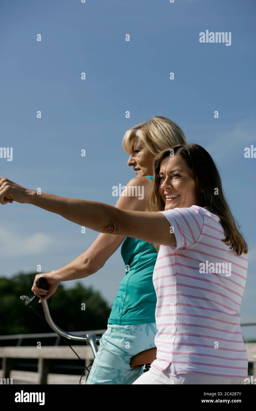 Two older women on a bike Stock Photo - Alamy