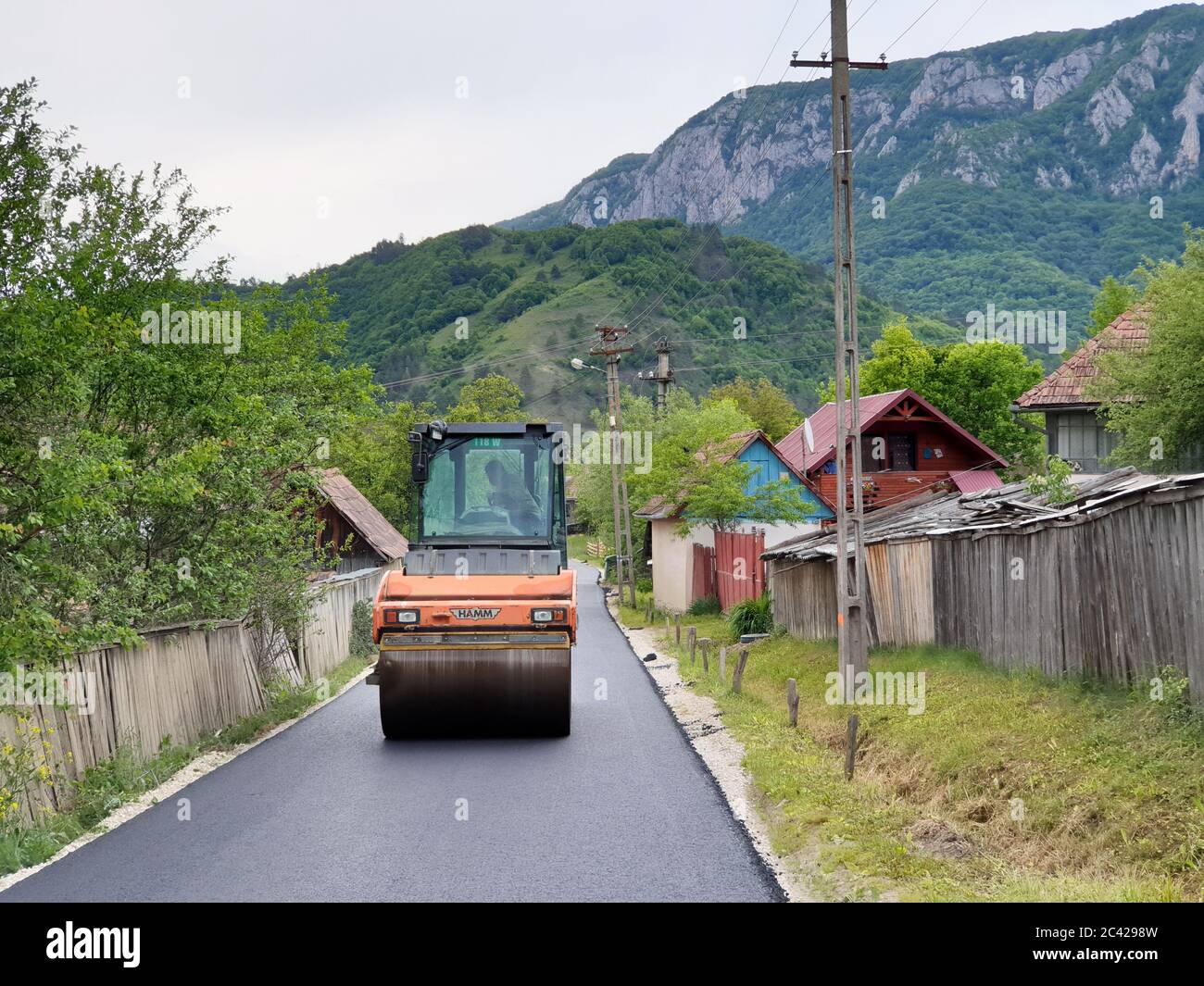 Asphalt pneumatic compactor roller on newly built village road in ...