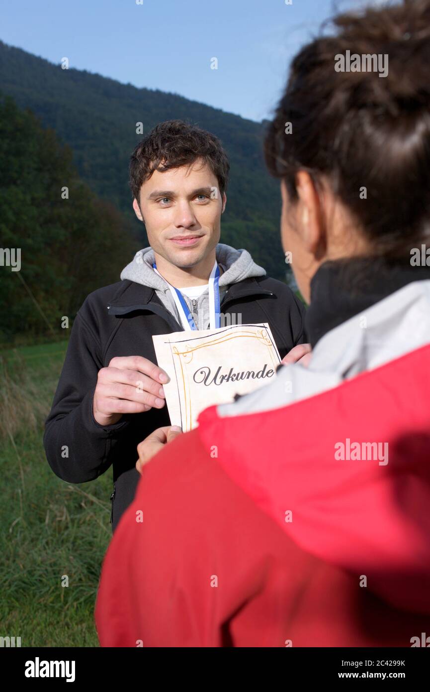 Man gives a certificate to a brunette woman - winner - mountain ...