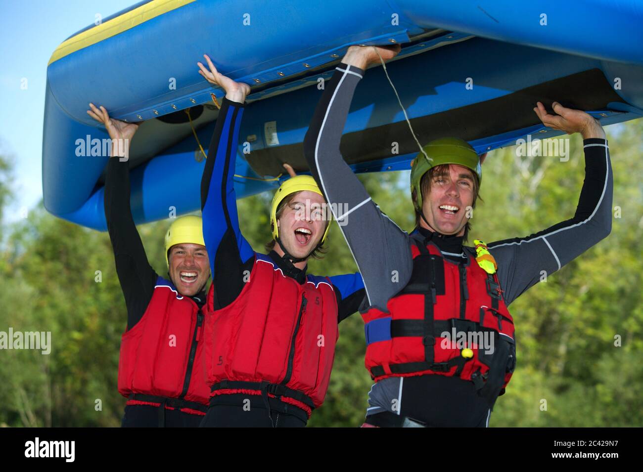 Three young men carry an inflatable boat - white water rafting Stock ...