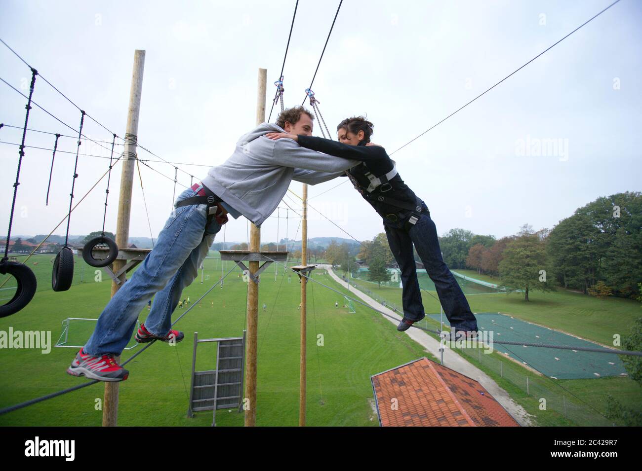 Man and woman face each other on a tightrope - trust - teamwork Stock ...