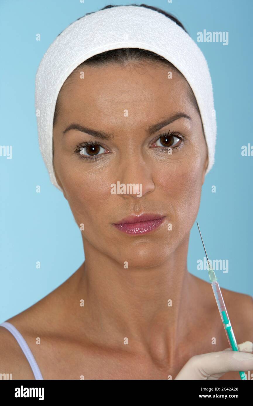 Woman holds an injection needle - cosmetic surgery Stock Photo - Alamy