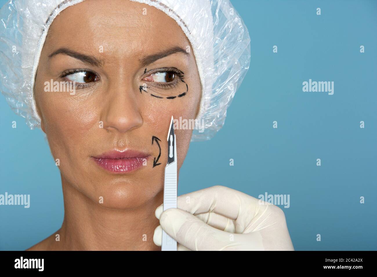 Young woman with an arrow mark on the corner of her mouth and eyelid ...