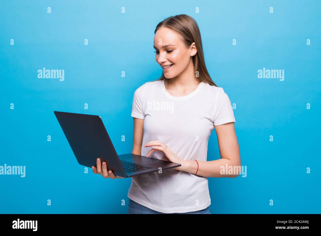 Portrait of a happy beautiful girl pointing finger at blank screen ...