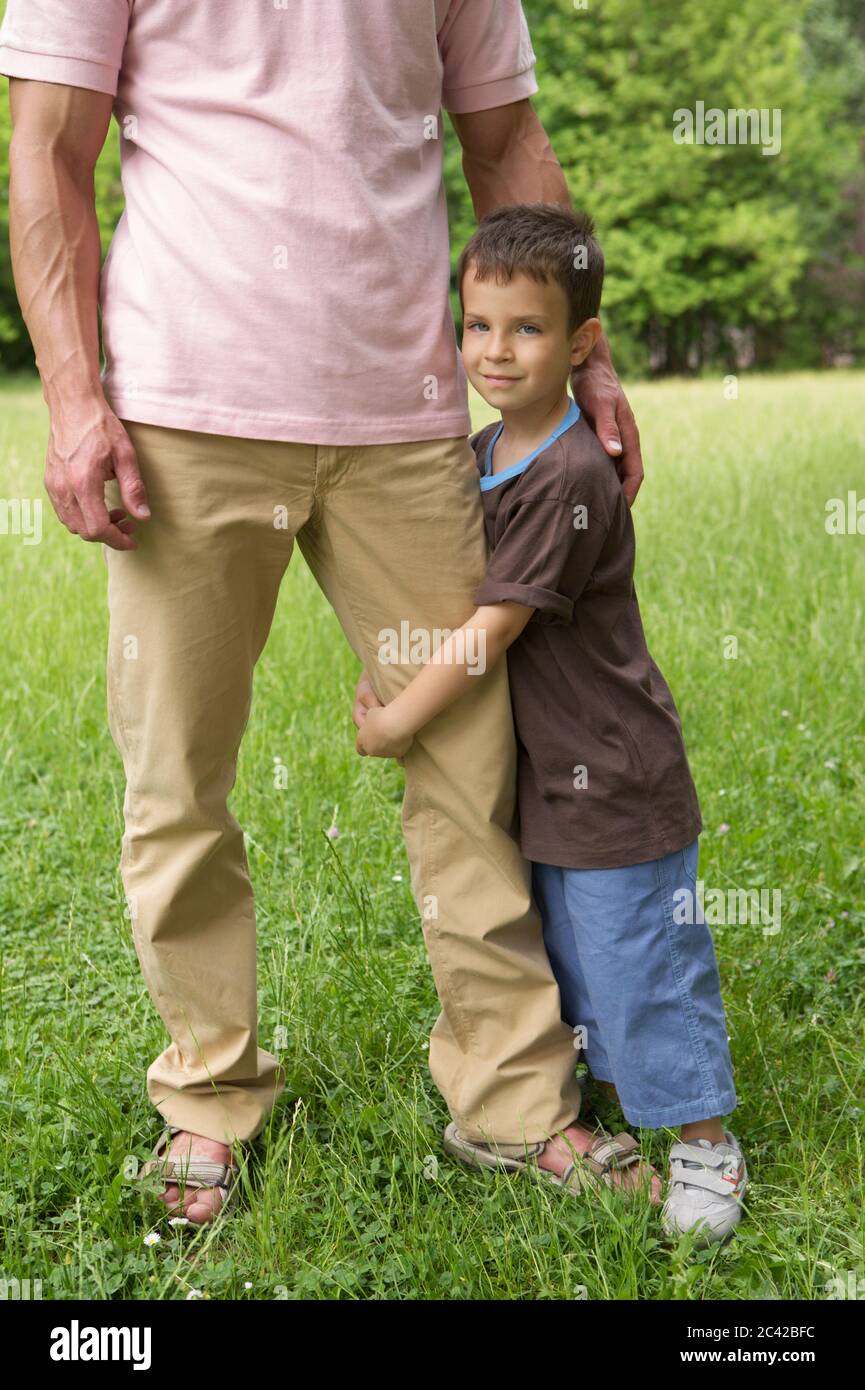 Boy (4 years) reaches for the leg of the father Stock Photo - Alamy