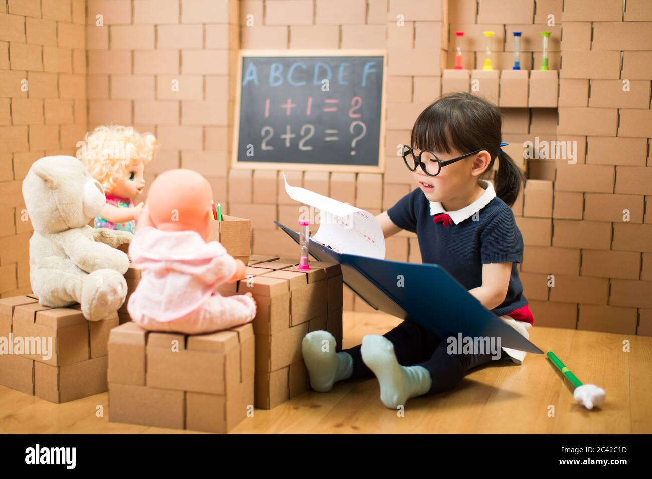 toddler girl pretend play as a teacher at home Stock Photo - Alamy