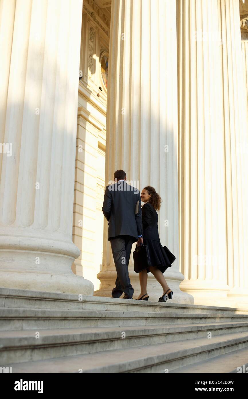 Two business people entering a building Stock Photo - Alamy