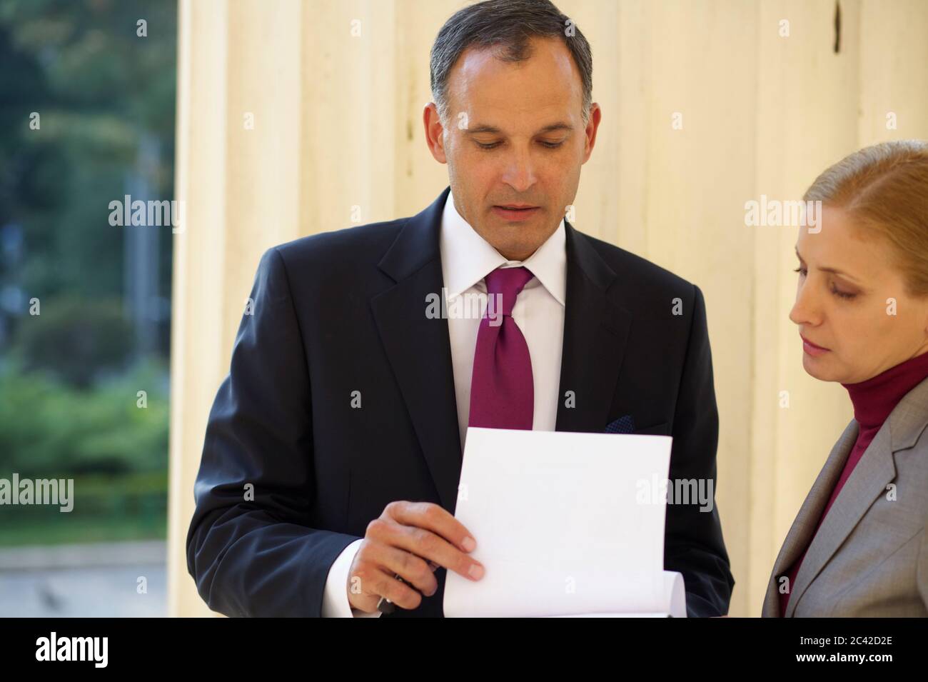 Two business people reading documents Stock Photo - Alamy
