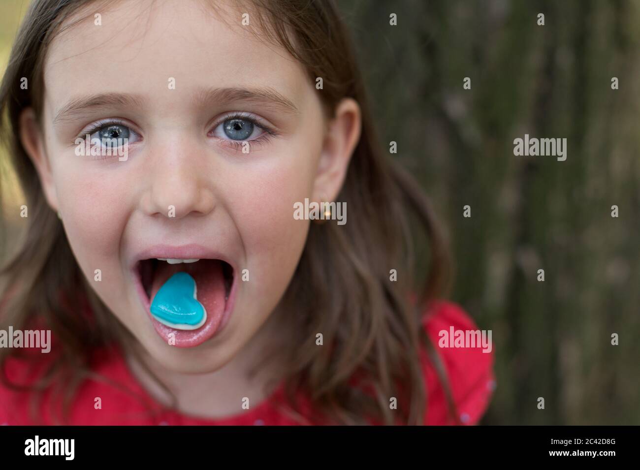 Girl with a candy in her mouth Stock Photo - Alamy
