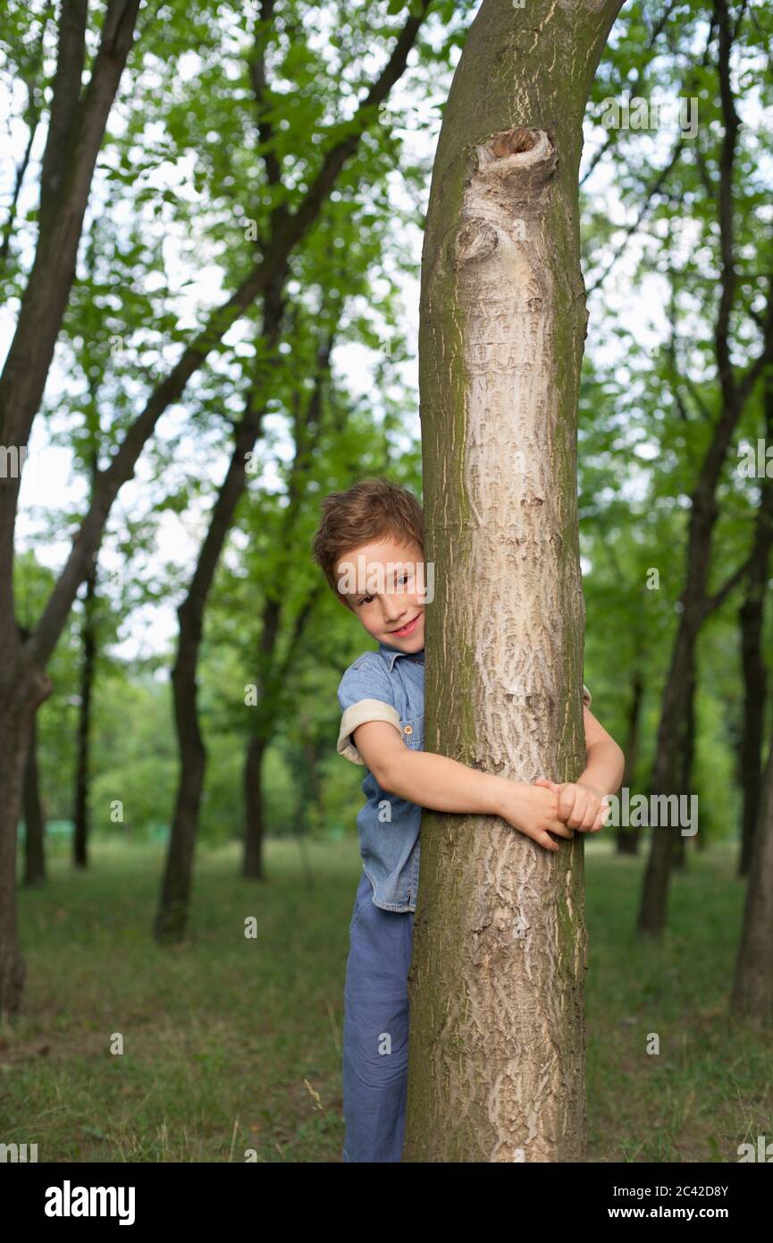 Boy hugging a tree Stock Photo - Alamy