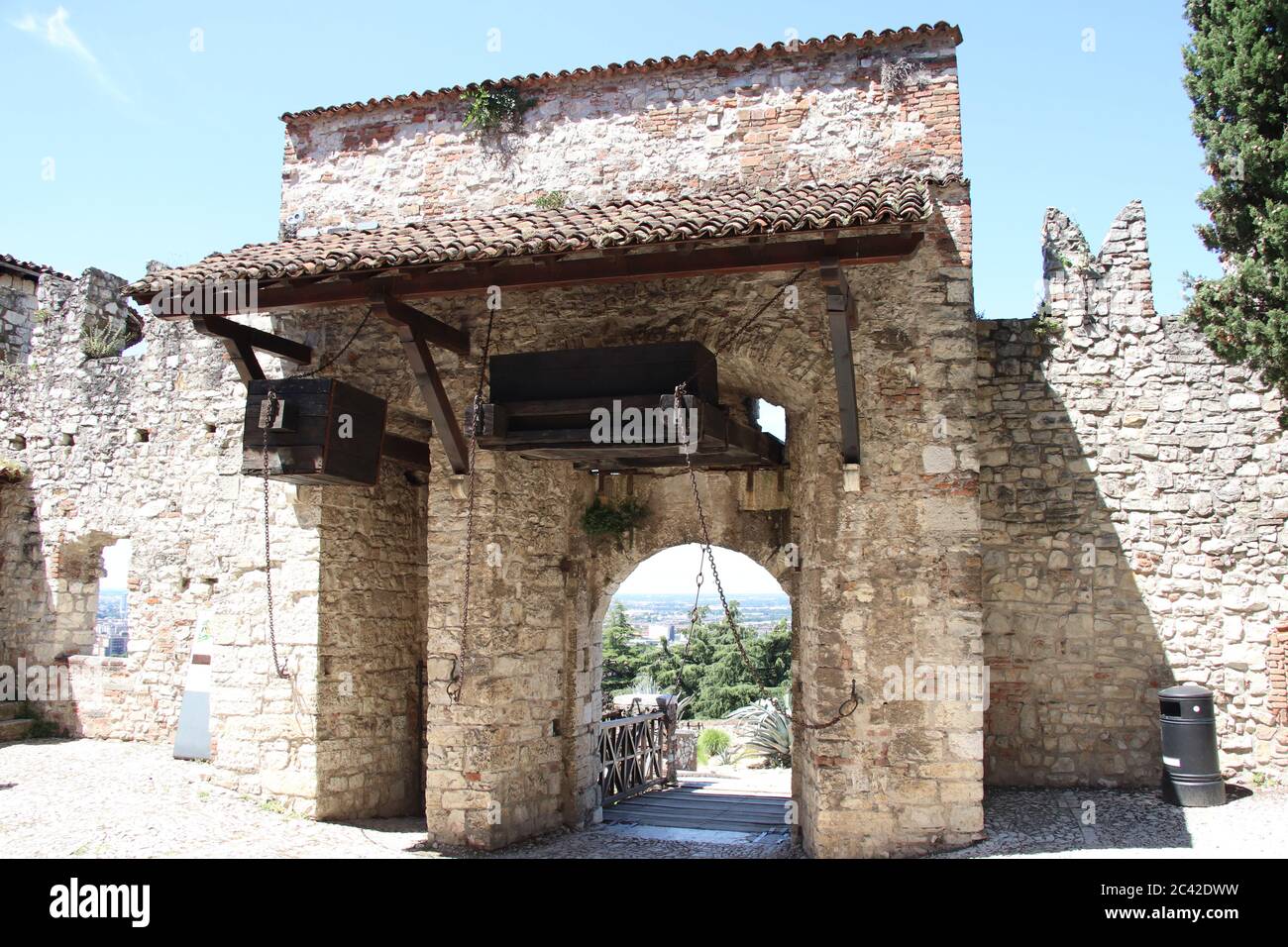 Stone wall with merlons and drawbridge gate of medieval castle of ...