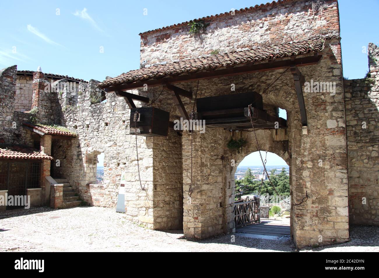 Stone wall with merlons and drawbridge gate of medieval castle of ...