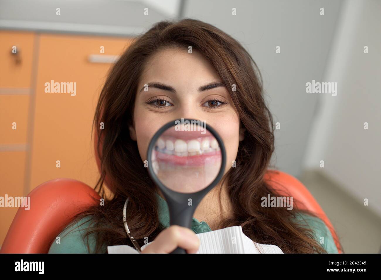 Patient shows teeth through a magnifying glass Stock Photo - Alamy