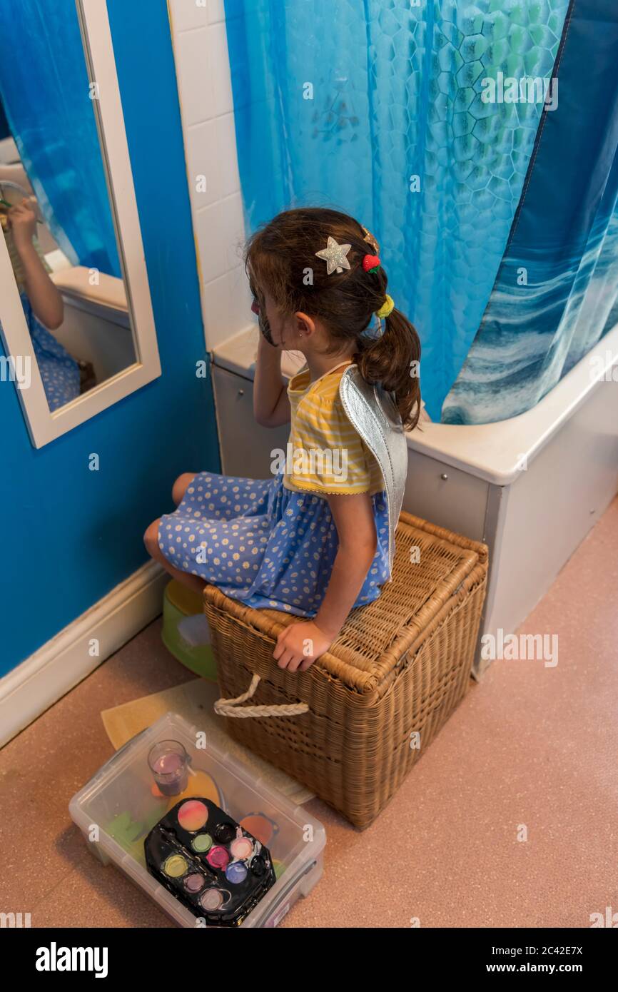 A young girl from poor deprived family is entertaining herself by face ...