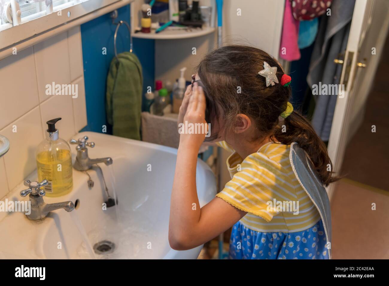 A young girl from poor deprived family is entertaining herself by face ...