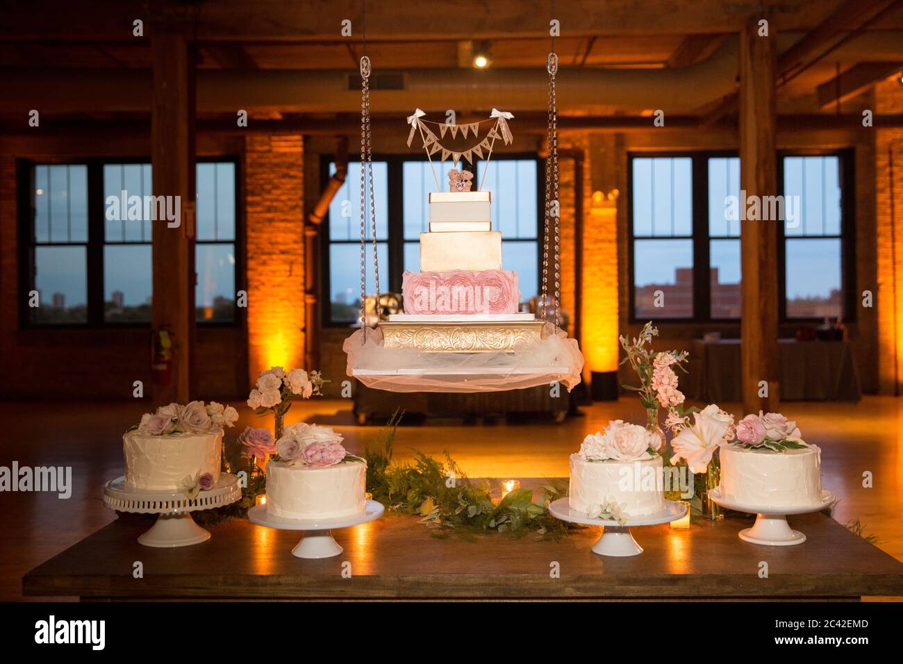 Wedding cake hanging on a swing in an evening setting Stock Photo - Alamy