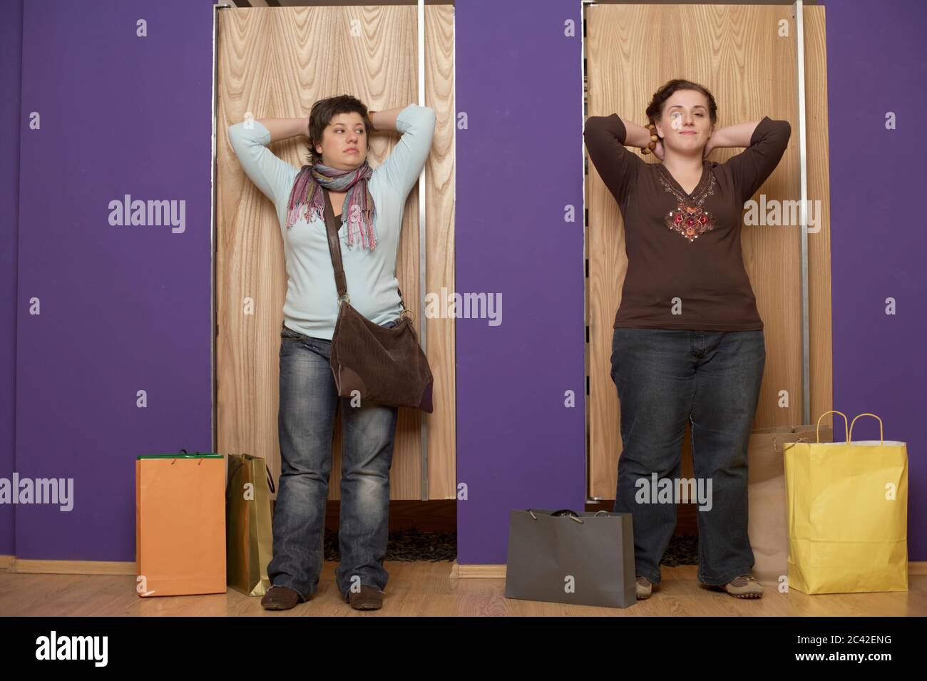 Two stout women stand in front of changing rooms - shopping - facial ...
